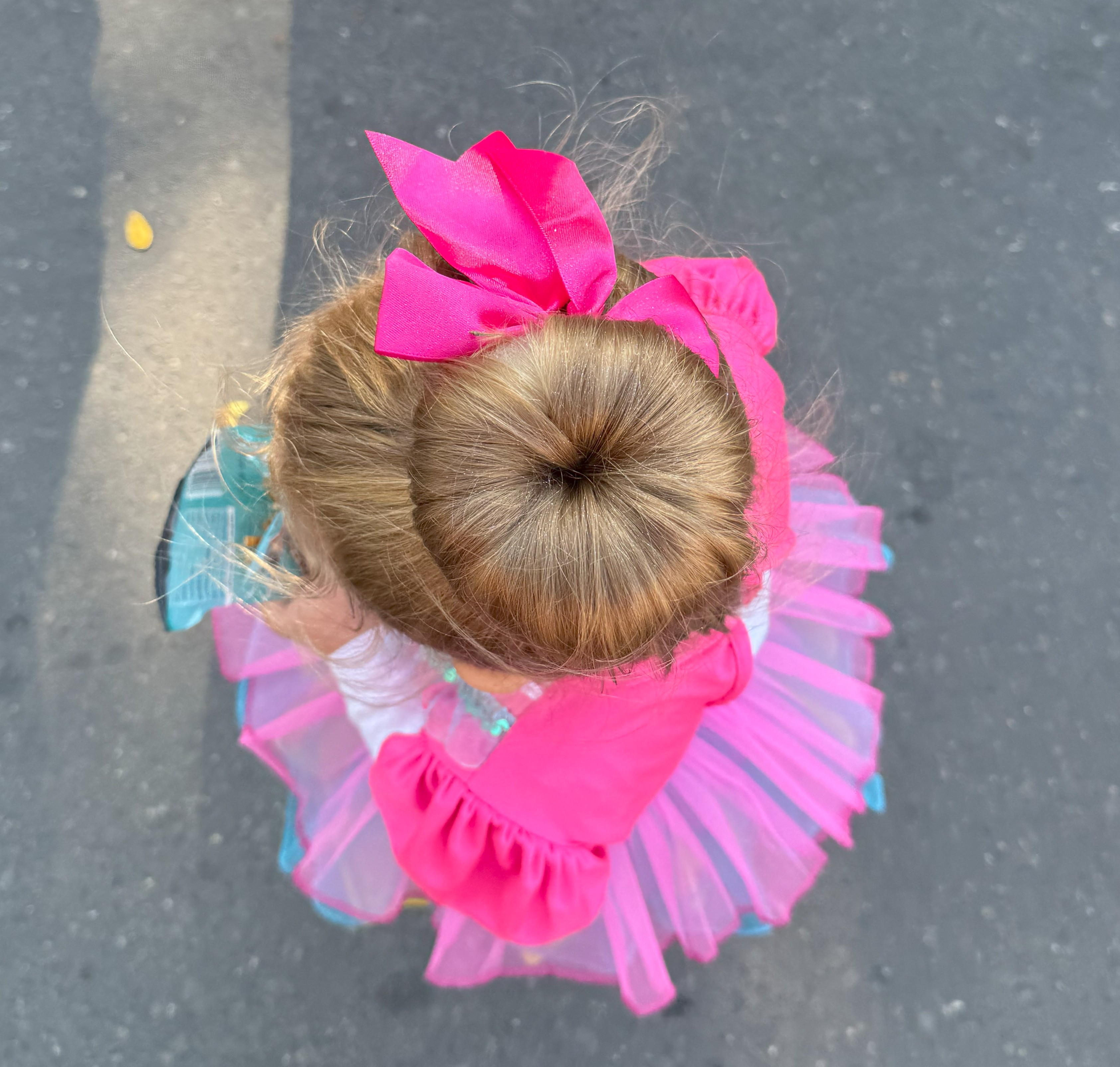 Child with pink bow and colorful tutu from above - Payhip